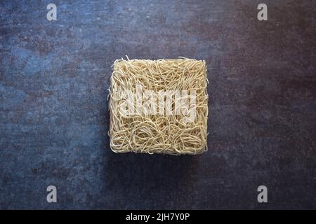 Raw whole dried square noodles block Stock Photo - Alamy