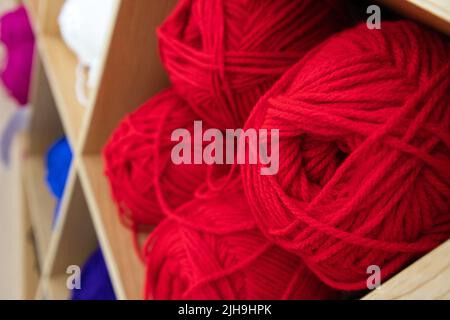 stack of colorful worsted wool yarn batch in square spaces of a shelf ...