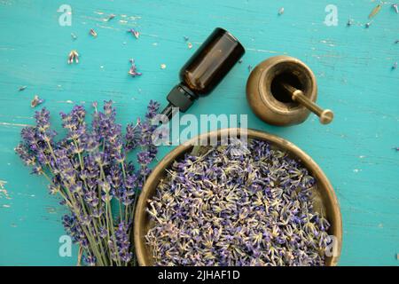 Flat lay of oil, bowl and bouquet of fresh lavender flowers on ...