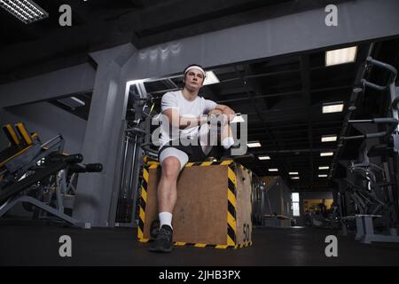 Full length shot of a sportsman stepping on a box, doing functional ...