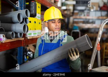 Latin american workman choosing supplies in shop of building materials ...
