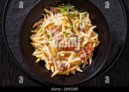 close-up of capunti pasta in cream pecorino cheese and pancetta sauce ...