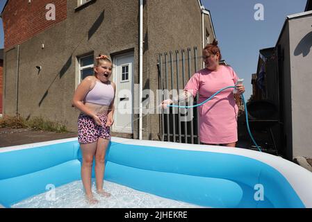 Danielle Lofthouse cools down her daughter Amelia Bradford, 10, with a ...