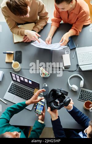 High angle view of team of developers discussing developing of new ...