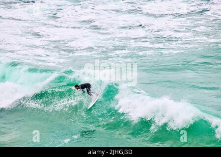 A surfer descends a surf wave of the Atlantic ocean off the Great ...