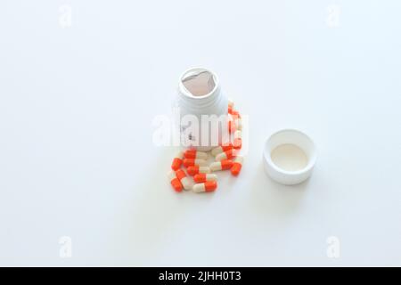 Group of orange pills over a white background Stock Photo - Alamy