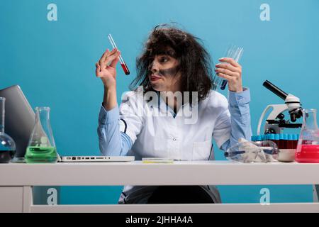 Crazy amusing chemist analyzing lab beaker and acting insane, being ...