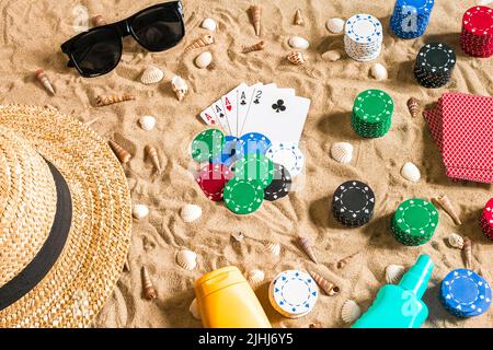 Beachpoker. Chips and cards on the sand. Around the seashells ...