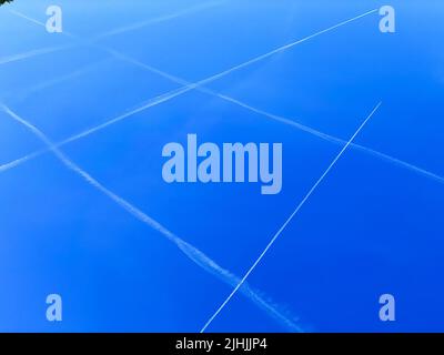 Many contrails cross each other in the blue sky Stock Photo - Alamy