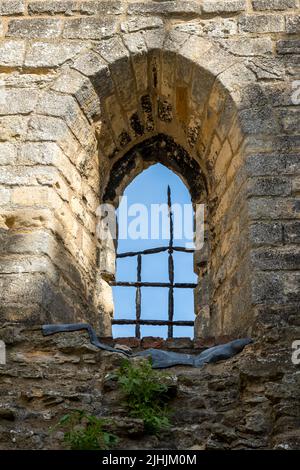 Arched window in castle wall with two round stained glass windows in ...