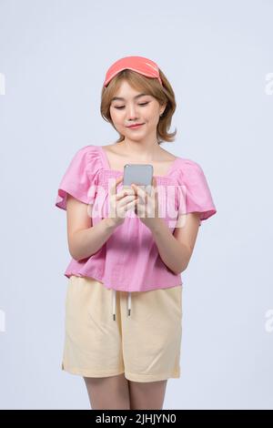 Young woman wearing pajama and sleep mask standing over yellow isolated ...