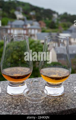 Two drams of scotch whiskey with view on old houses on background ...