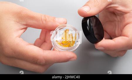 golden cannabis wax in female hands in a box, strong thc extract Stock ...