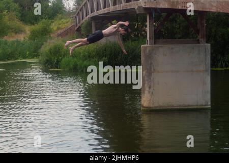 19th July, 2022. Youngsters diving on a bridge above the Jubilee River ...