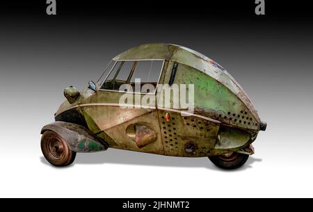 A side view of a 1950 Fend Flitzer Micro car on a knocked out white ...