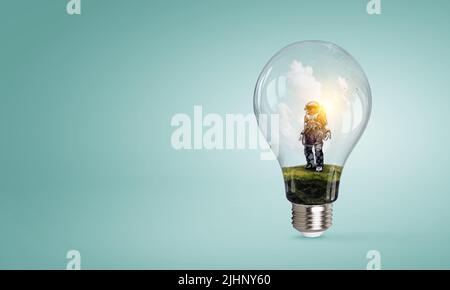 Spaceman inside light bulb . Mixed media Stock Photo - Alamy