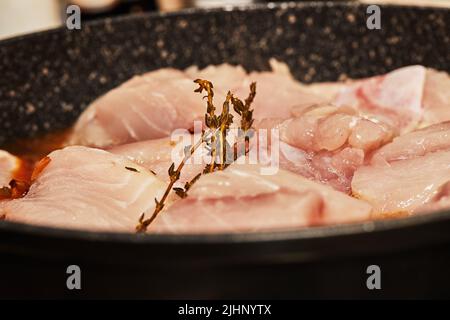 Fish stewed with carrots, mushrooms and potatoes is fried in pan on gas ...