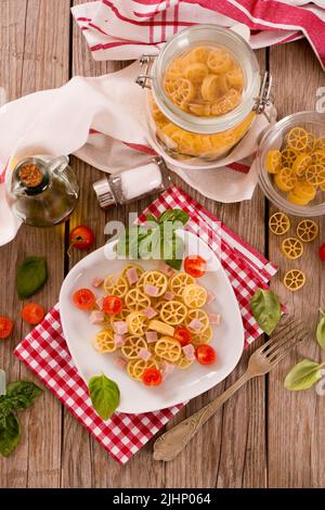 Ruote pasta with tomato and ham Stock Photo - Alamy