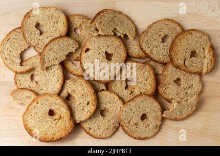 Mini rolls of baked bread on wooden background. Bread chips Stock Photo ...