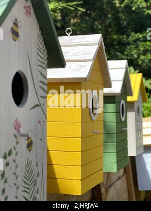 A vertical shot of wooden birdhouses in different sizes on a tree Stock ...