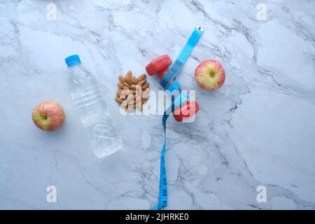 fresh drinking water, apple and a pink color dumbbell on table Stock ...