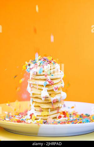 A closeup of a celebratory pancake on a plate with colorful oatmeal ...