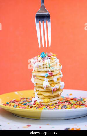 A closeup of a celebratory pancake on a plate with colorful oatmeal ...