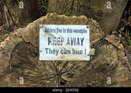 Sign warning of the presence of Adder snakes in a woodpile, Suffolk ...