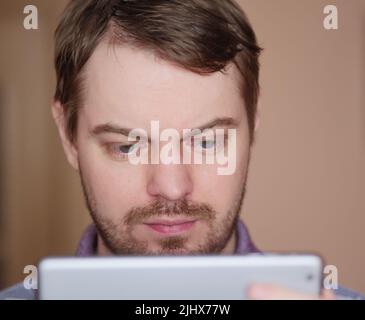 Young emotional man with pda looking down at camera Stock Photo - Alamy