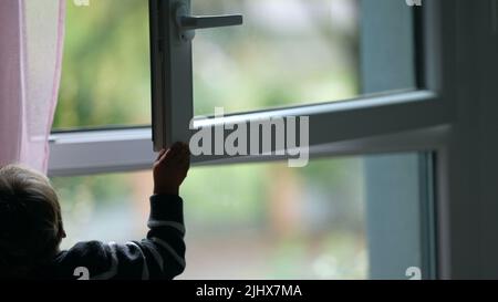 Child closing window. Toddler closes window Stock Photo - Alamy