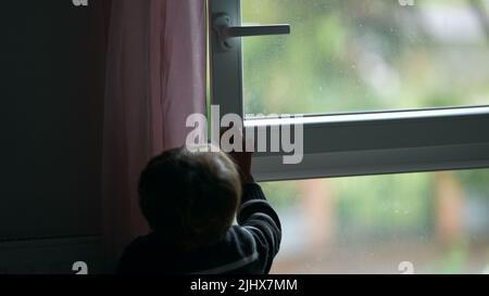 Child closing window. Toddler closes window Stock Photo - Alamy
