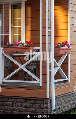 a tray with natural flowers hanging on the veranda of the house. High ...