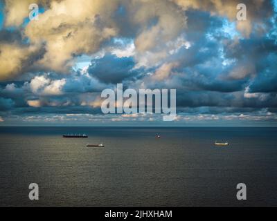 Moody sky over container ships swimming on sea gulf, aerial landscape ...