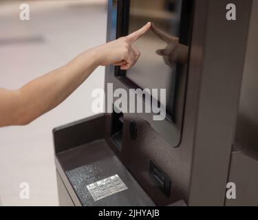 Faceless woman using touchscreen ATM Stock Photo - Alamy