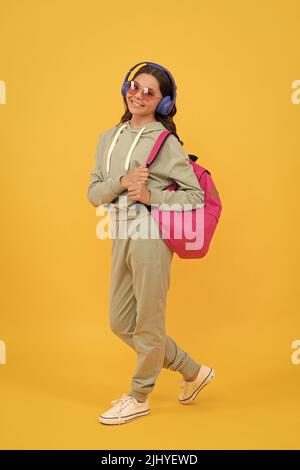 happy child in earphones carry backpack. back to school. knowledge and ...