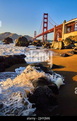 Waves crash on sandy beach under cloudy sky at sunset Stock Photo - Alamy
