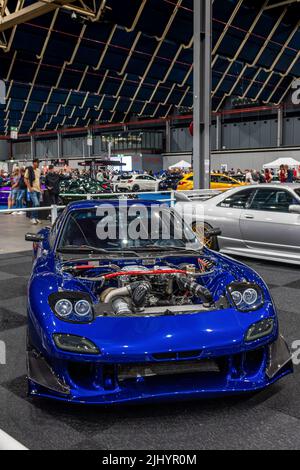 A blue Mazda RX 7, a sportscar model at the World of Cars show, built ...