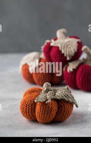 Cute crochet knitted orange pumpkins on black background with a ball of ...