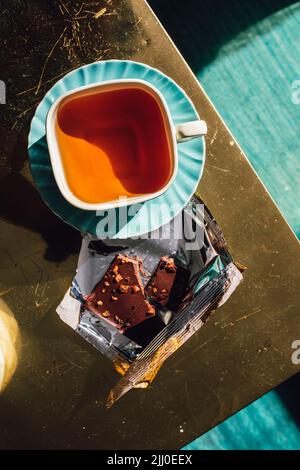 afternoon tea in square teal teacup and saucer with chocolate in gold ...