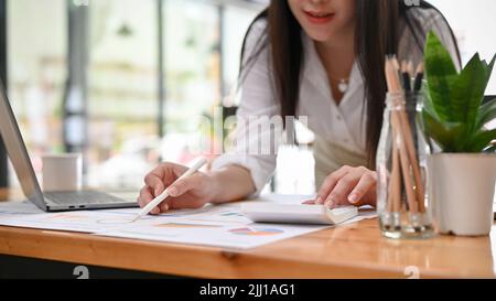 A confident asian female financial consultant presenting the business ...