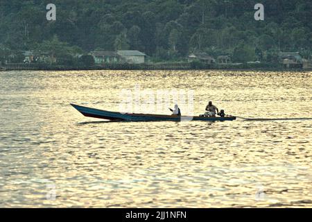 People travelling on a motorized longboat on Segah river in Tanjung ...