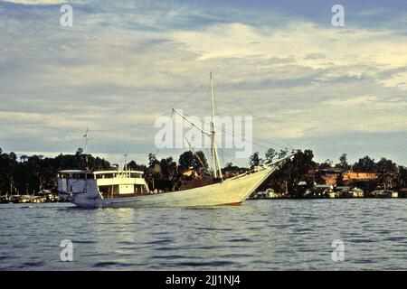 A boat sailing on Segah river, in a background of riverport and ...