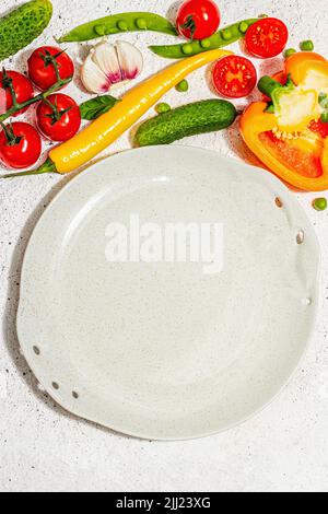 Vegan table setting. Assorted of ripe fresh vegetables, empty plate ...