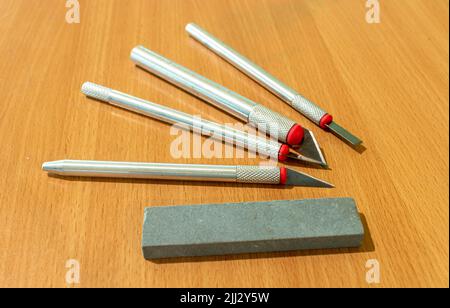 Various sharp precision craft knives with different blades on a ...