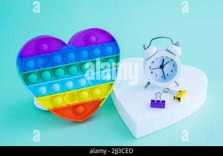 Close up of stationery, clock and silicone toy popit on yellow ...