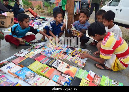 Indonesia, 2021 : children reading a book in a public space park at ...
