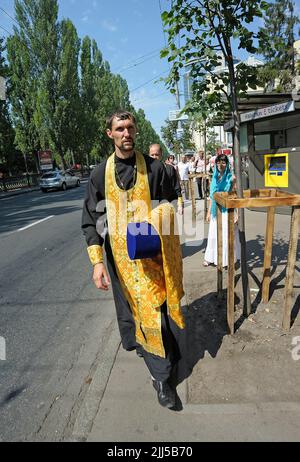 Middle aged monk in a cassock walking down the street, portrait. July ...