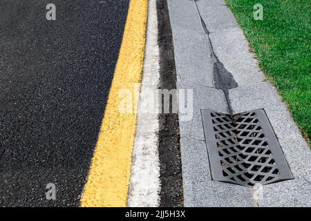 gutter of a stormwater drainage system on the side of an road with ...