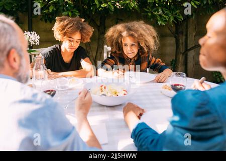 Diverse kids sitting at tables in classroom at primary school or ...
