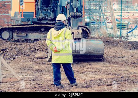 Excavator digging and levelling ground on construction site. Digging to ...
